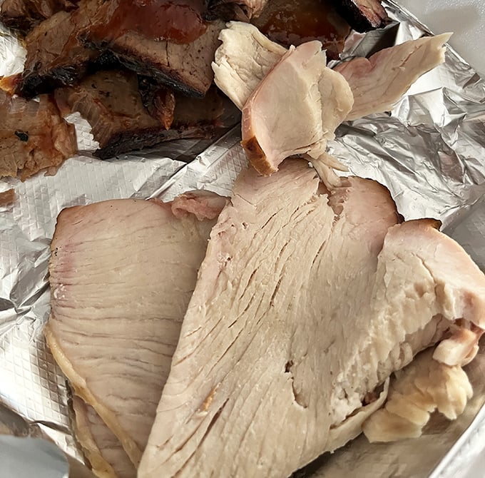 Smoked turkey so moist and tender it defies poultry physics. This isn't your dry Thanksgiving nightmare—this is turkey nirvana.