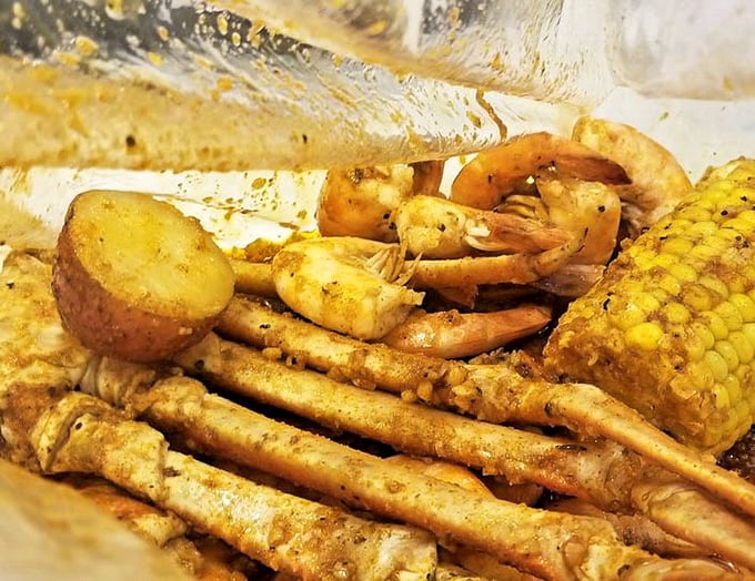The seafood boil in all its glory—where shrimp, crab legs, and corn bathe together in seasoned harmony like old friends at a spicy spa.