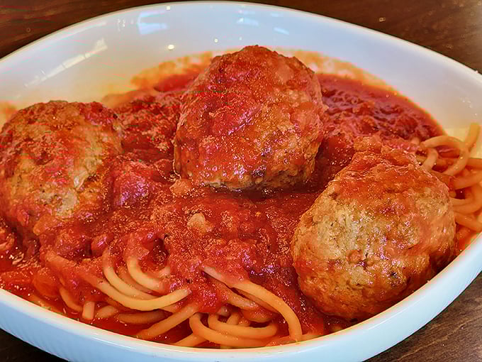 These meatballs aren't just sitting on the pasta—they're holding court. Three tender spheres of seasoned perfection that would make any nonna nod in approval.