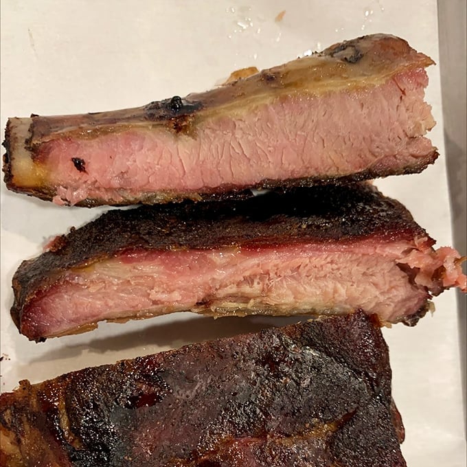 Behold the holy grail of barbecue—perfectly smoked ribs with that coveted pink smoke ring. The bark on these beauties tells stories of patience and expertise.