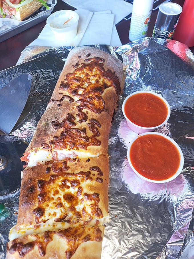 Behold the stromboli in all its glory—a magnificent tube of melted cheese and dough with marinara sidekicks standing by.