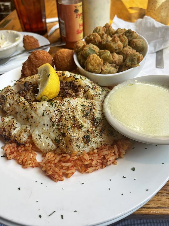 This perfectly seasoned fish rests on a bed of red rice like royalty, with fried okra standing guard and lemon ready for duty.