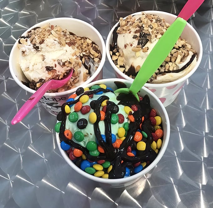 Three cups of joy sitting on a metal table—nuts, fudge, and candy-covered creations that make adulthood worth the trouble.