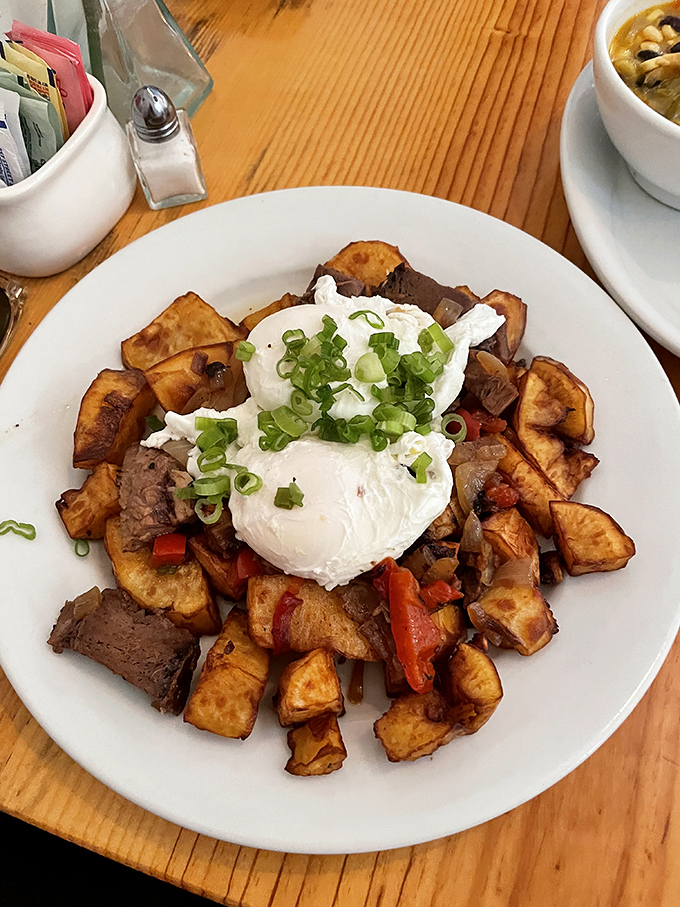 Breakfast alchemy at its finest – crispy sweet potatoes, savory meat, and those perfectly poached eggs creating the morning gold standard.