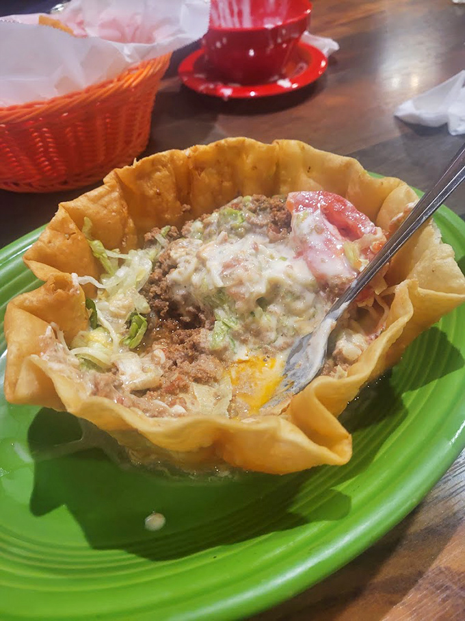 The taco salad arrives like edible architecture—crispy shell cradling seasoned meat and toppings that somehow makes salad feel like an indulgence.
