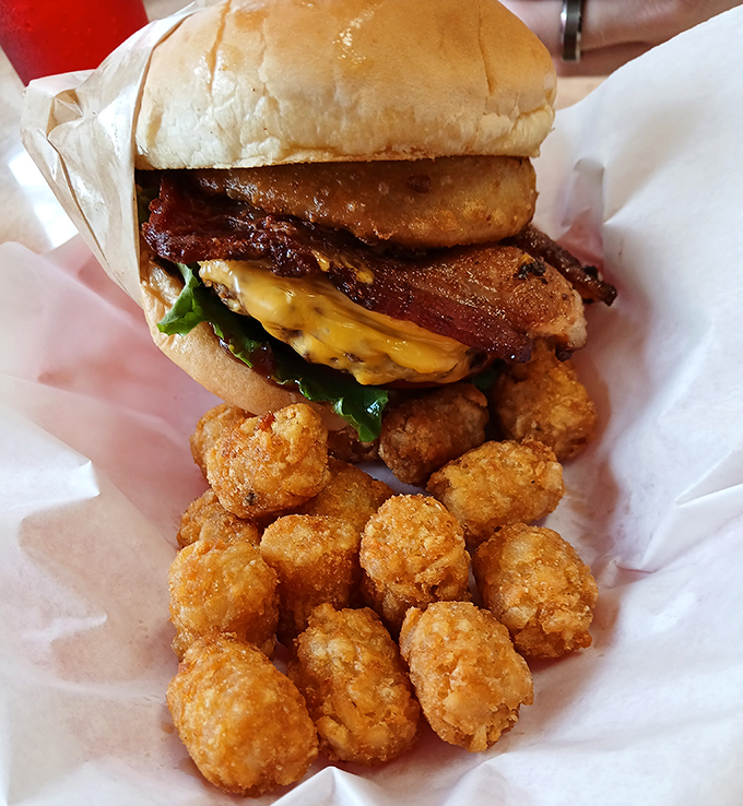 The perfect partnership: a towering burger alongside golden tater tots. Comfort food that speaks directly to your inner child.