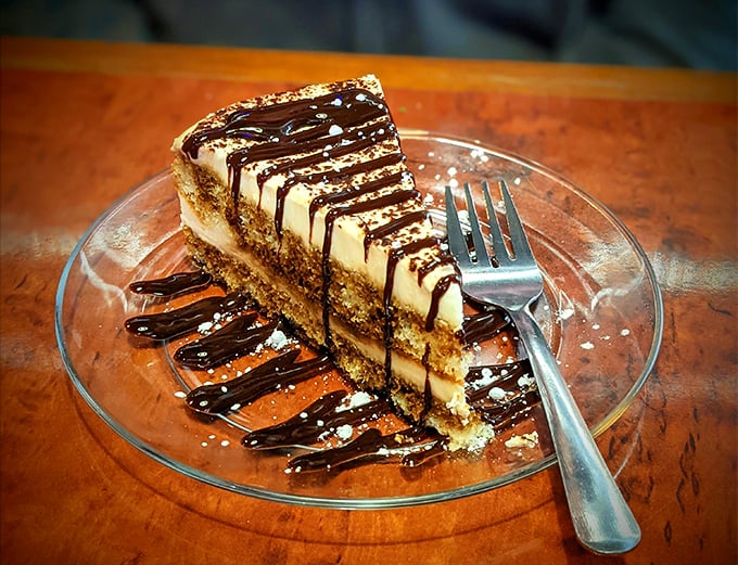 This tiramisu isn't just dessert—it's a masterclass in textural contrast, with chocolate drizzle creating edible art on the plate.
