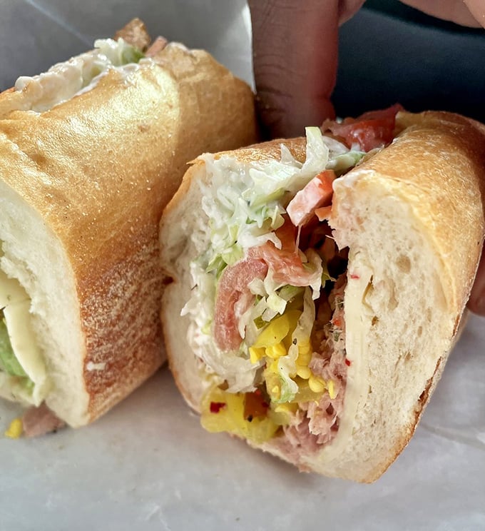 Cross-section perfection reveals the careful construction—each ingredient playing its part in the sandwich symphony, with pickled peppers providing the high notes.