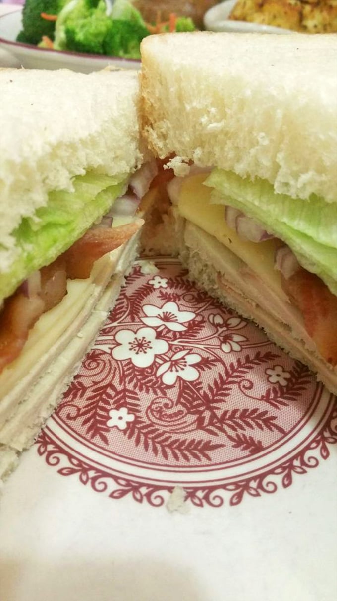 This isn't just a sandwich—it's architectural achievement with layers of deli meat, cheese, and fresh veggies on pillowy white bread. No tweezers required.