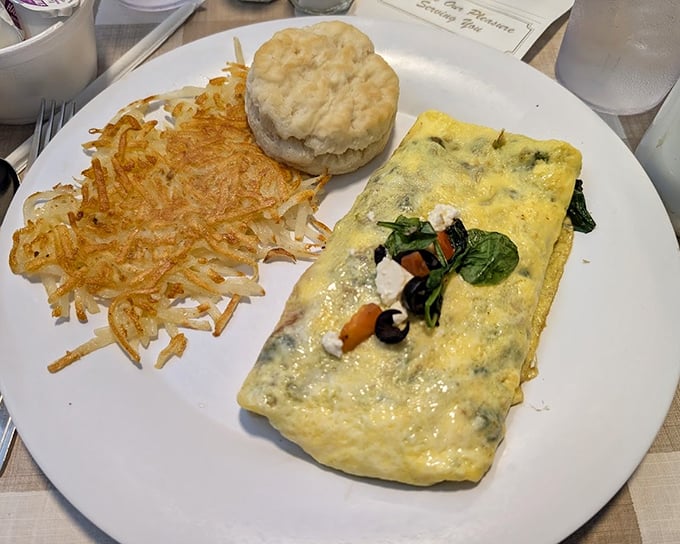 This omelet isn't just folded eggs—it's a vegetable treasure chest with perfectly crispy hash browns and a biscuit that's practically begging for butter.