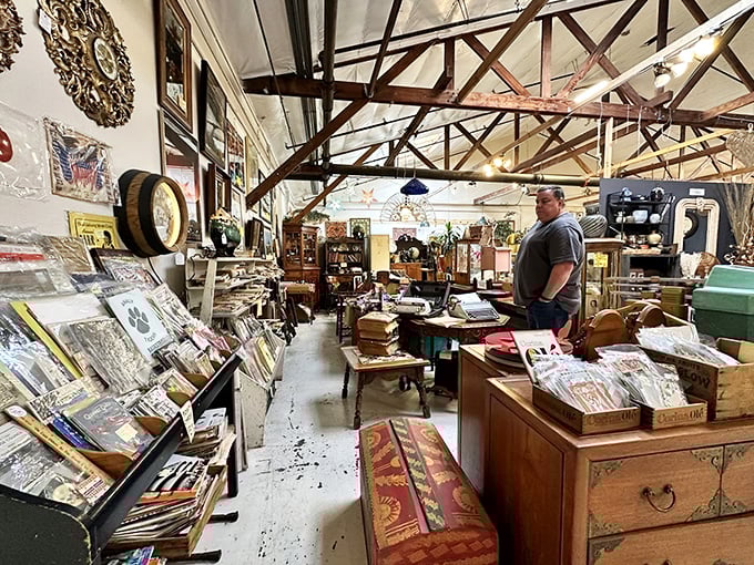 A browser contemplates his next discovery among shelves of vinyl records and vintage books—proof that one person's nostalgia is another's treasure hunt.