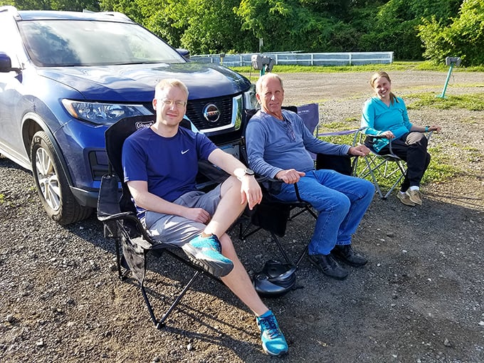 These folks have clearly mastered drive-in etiquette: comfortable chairs, strategic parking, and that unmistakable look of people who've discovered life's perfect simple pleasure.