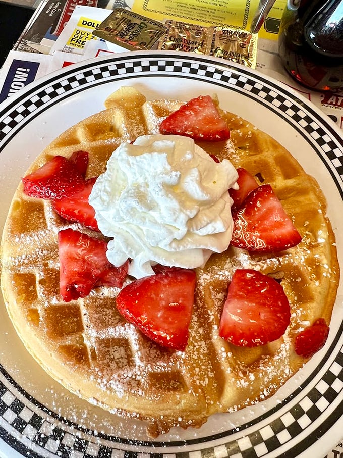 Fresh strawberries dancing on fluffy waffle squares like nature's own confetti – breakfast never looked so photogenic.