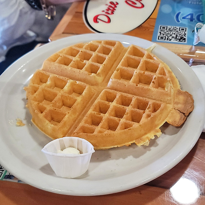 The Belgian waffle stands proud and golden, awaiting its maple destiny. Crisp exterior, fluffy interior – architecture that would make Frank Lloyd Wright weep with joy.