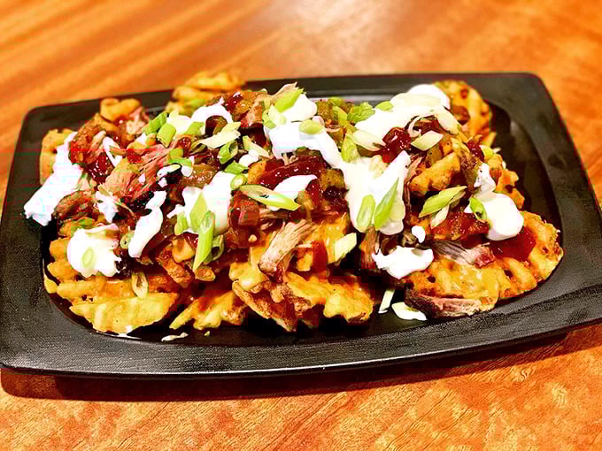 Waffle fry nachos that defy gravity and good sense – a mountain of crispy potatoes, pulled pork, and sauces that somehow manages to disappear mysteriously fast.