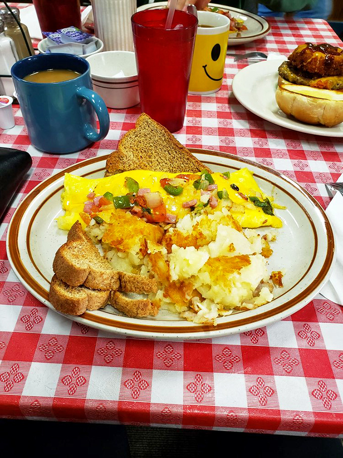This isn't just an omelet—it's a masterpiece of morning engineering, with perfectly diced veggies and cheese melted just right. Toast stands ready for dipping duty.