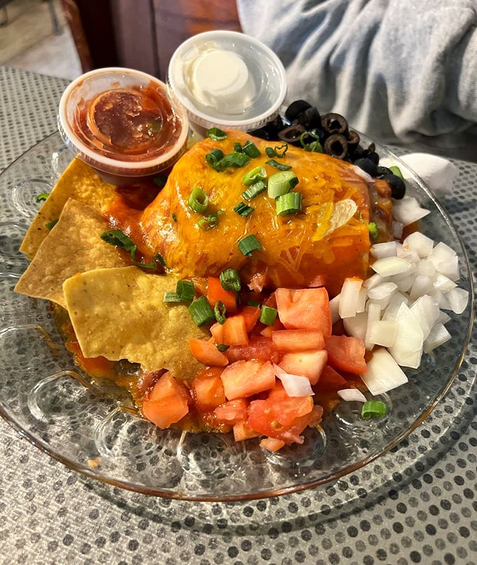 This isn't just any wet burrito – it's a color-coordinated flavor bomb draped in melted cheese with fresh veggies standing at attention around the perimeter. 