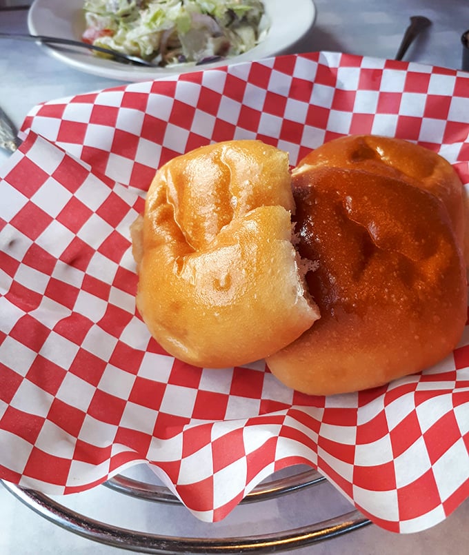 These aren't just dinner rolls—they're pillowy vessels of joy served on classic red-and-white checkered paper. Resistance is futile.