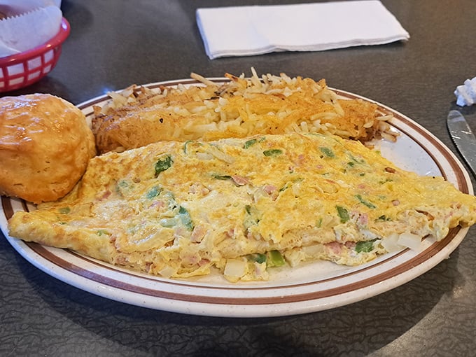 This isn't just an omelette—it's an architectural marvel of eggs, fillings, and hash browns that would make Frank Lloyd Wright weep with joy.