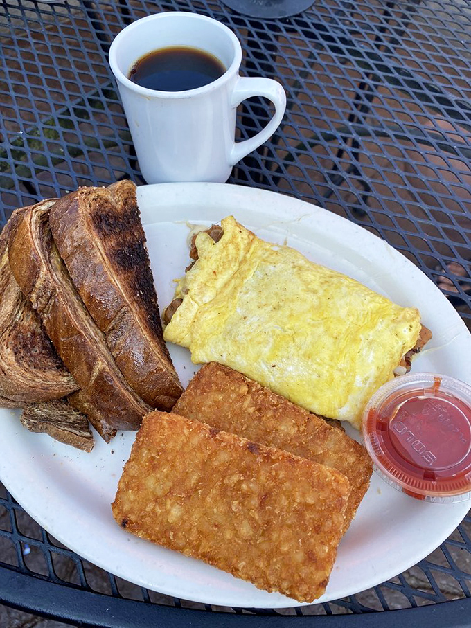 The breakfast trinity: perfectly folded omelet, crispy hash browns, and toast the color of a Midwestern summer sunset. Add coffee and solve world problems.