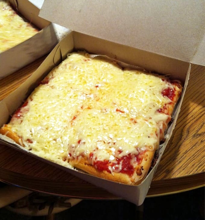 The rectangular cheese pizza comes in a simple white box—no fancy packaging needed when what's inside is this good.