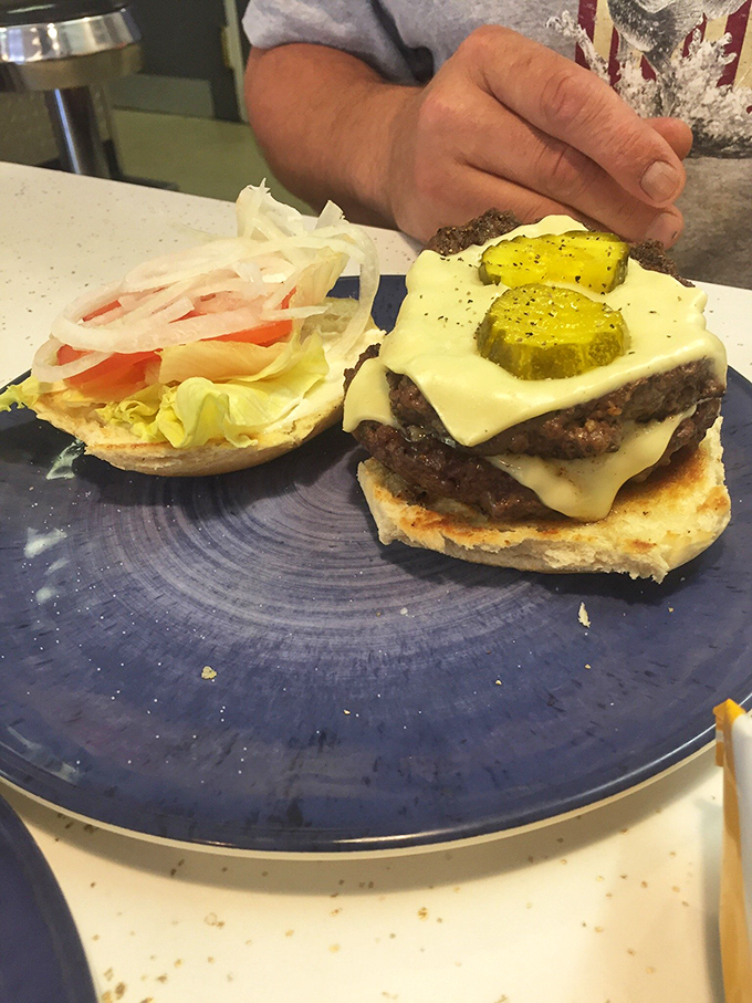 This isn't just a cheeseburger; it's a masterclass in simplicity. Note the pickle coins standing guard like delicious sentinels.