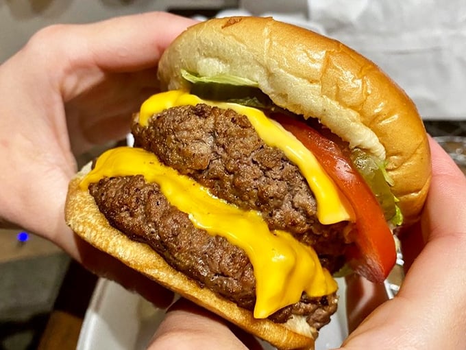 This isn't just a cheeseburger; it's edible architecture – a perfect stack of beef, cheese, and fresh veggies on a pillowy bun.