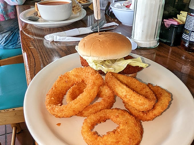 A sandwich that requires both hands and a strategy. Those golden onion rings aren't just sides – they're supporting characters in this delicious drama.