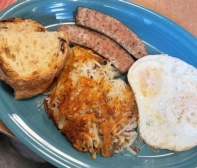 This isn't just breakfast—it's a perfectly choreographed dance of crispy hash browns, savory sausage, and a sunny-side egg waiting for its standing ovation.