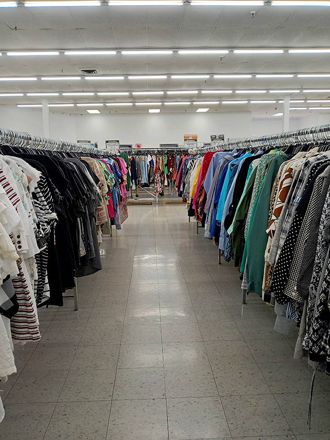 The clothing section sprawls endlessly, a rainbow of possibilities where fashion decades collide in beautiful chaos.