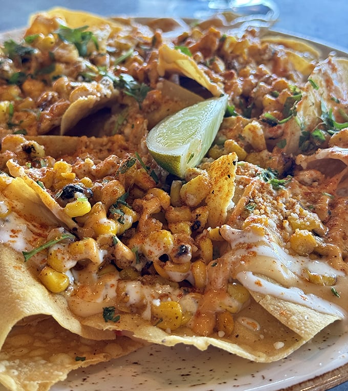 Street corn nachos that put ordinary bar food to shame. That lime wedge isn't just garnish—it's the conductor of this symphony of flavors.
