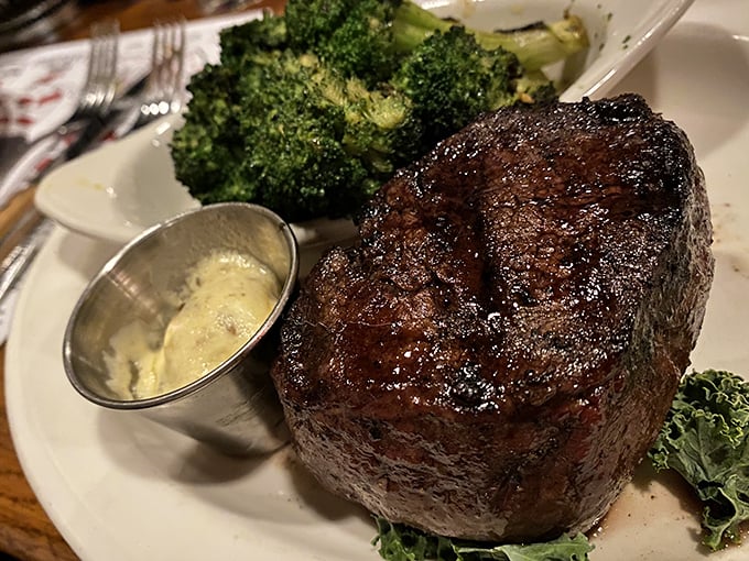 Behold the filet mignon in its natural habitat—perfectly seared, impossibly tender, and accompanied by a dollop of butter slowly melting into meaty perfection.