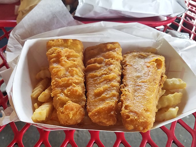 Golden fish planks nestled atop a bed of fries – seafood that's traveled inland but hasn't forgotten its crispy, delicious purpose.
