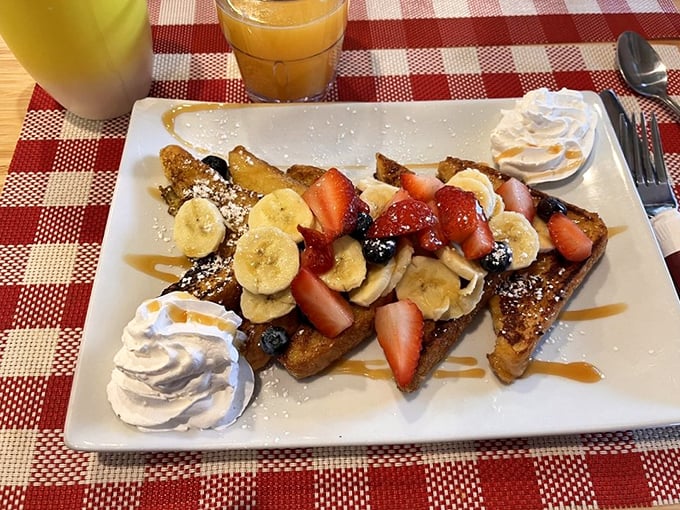 The legendary French toast arrives like edible art—golden triangles adorned with fresh fruit and whipped cream that make IHOP weep with inadequacy.
