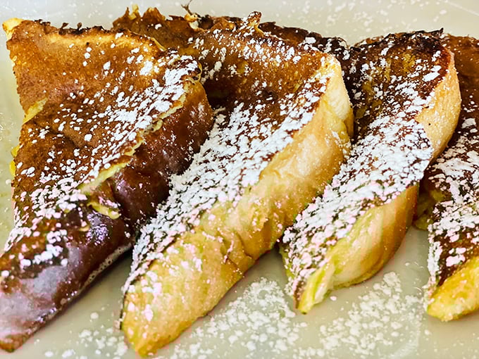 French toast that's achieved golden-brown perfection, dusted with powdered sugar like freshly fallen snow on a winter morning in Ohio.