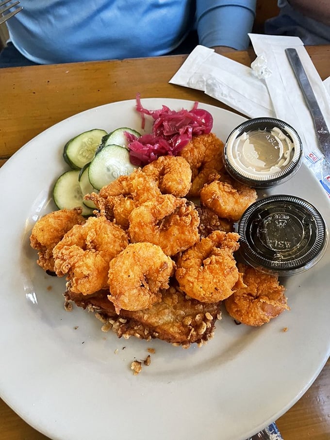 Golden-fried shrimp that snap with freshness, served with cooling cucumber slices and pickled onions – a trio that belongs together like retirees and early bird specials.