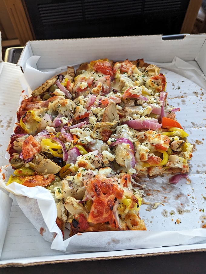 The Greek pizza doesn't just nod to Mediterranean flavors – it performs a full Zorba dance on your taste buds with feta, olives, and vibrant veggies.