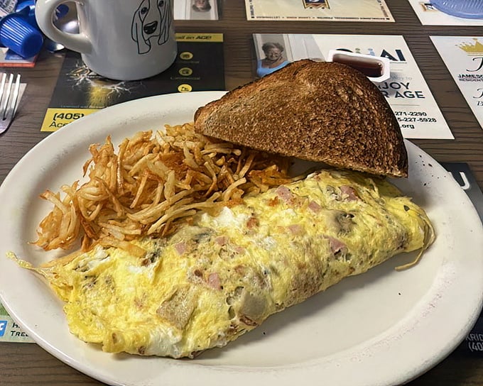 This isn't just an omelet – it's a masterclass in breakfast architecture, with perfectly folded eggs embracing ham and cheese like old friends reuniting.