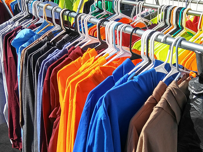 A rainbow of t-shirts hanging like colorful soldiers – each one ready to become someone's favorite weekend warrior uniform.