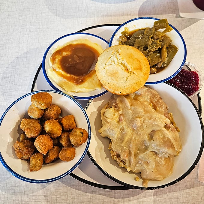 A proper Southern meat-and-three isn't just a meal—it's a cultural statement served in perfectly portioned blue-rimmed bowls.