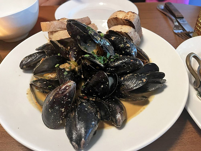 These mussels aren't just showing off their muscles – they're swimming in a broth so good you'll be plotting ways to drink it unnoticed.