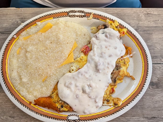 This omelet, draped in country gravy with cheese peeking out, is what breakfast dreams are made of – comfort food elevated to an art form.