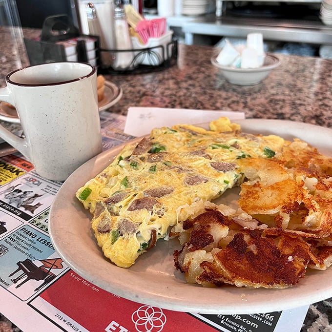 This isn't just an omelet—it's breakfast architecture. Perfectly folded eggs housing a treasure of fillings, with crispy potatoes standing guard on the side.
