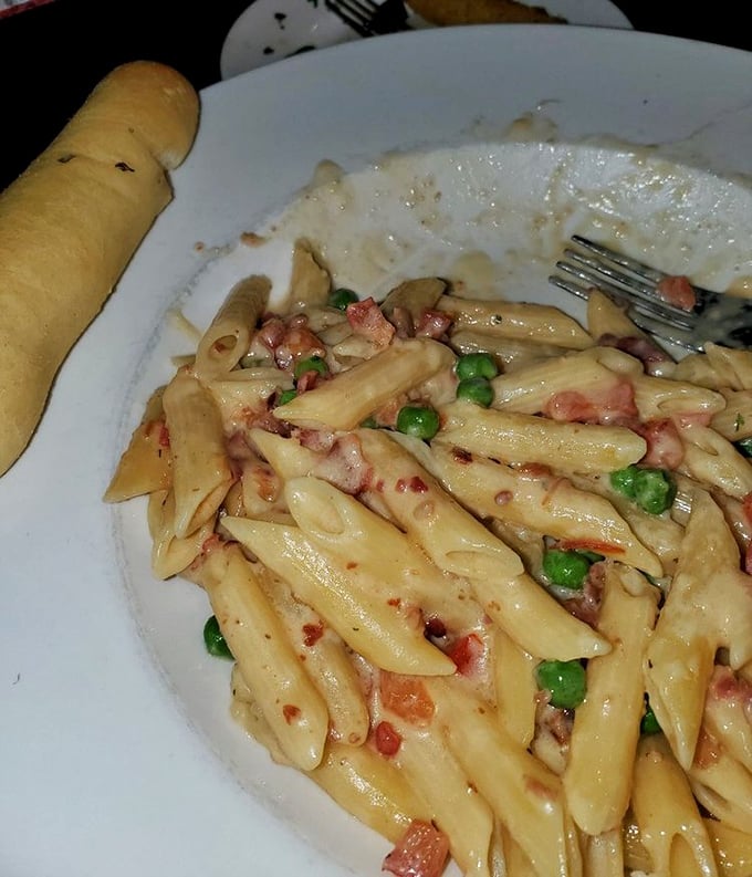 Pasta carbonara that doesn't skimp on the good stuff—creamy sauce clinging to each penne, with peas and bacon adding pops of color and flavor. Comfort in a bowl.