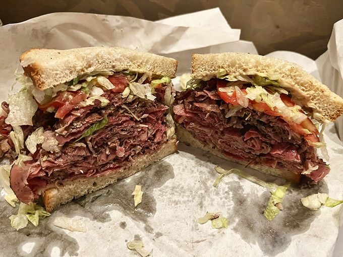 This pastrami sandwich isn't just stacked – it's an architectural marvel that would make Frank Lloyd Wright put down his blueprints and pick up a napkin.
