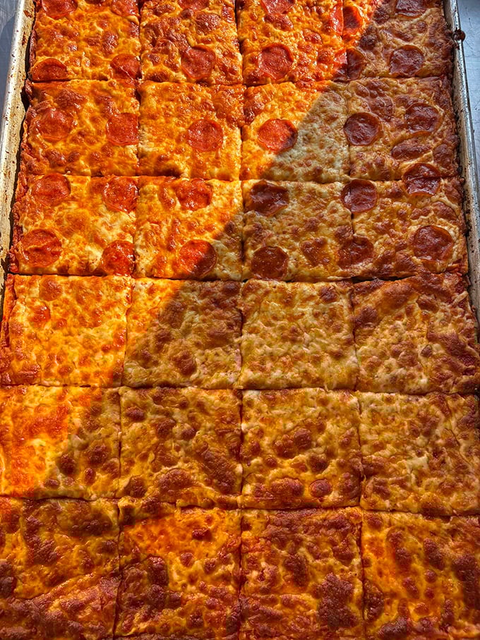 Pizza squares that defy geometry – somehow each piece manages to be the perfect corner slice with those crispy, caramelized edges.