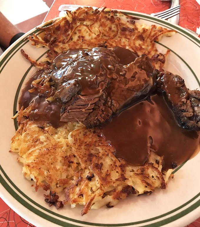 This isn't just pot roast—it's a comfort food masterpiece swimming in rich gravy, surrounded by crispy hash browns that deserve their own fan club.
