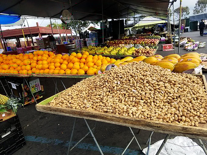 Fruit mountains! This produce stand's impressive display of oranges, bananas, and peanuts could feed a small army of health-conscious treasure hunters.