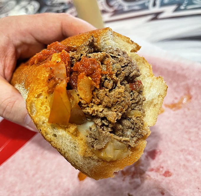 Behold the provolone cheesesteak in its natural habitat – wax paper. The marriage of beef, onions, and melted cheese creates sandwich nirvana.