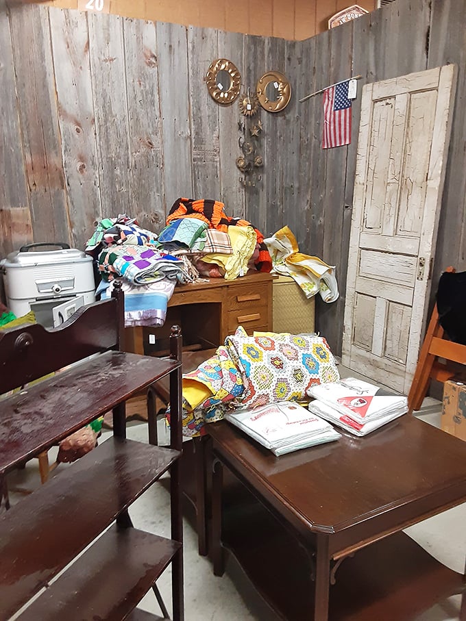 Grandma's quilts and vintage linens create a colorful tapestry of Americana against weathered barn wood walls – comfort in fabric form.